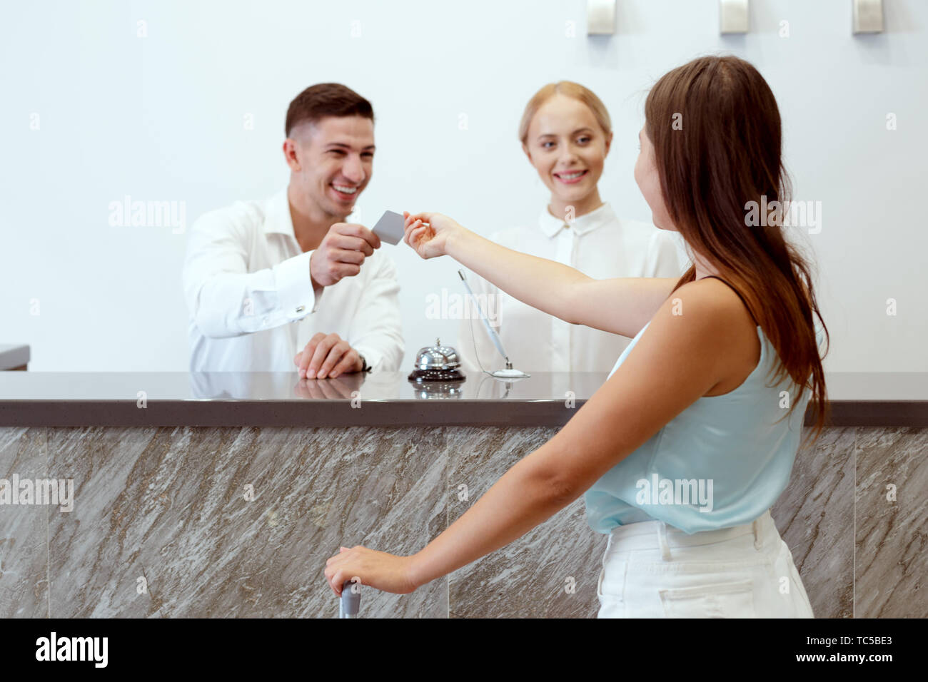 Woman Checking In At Hotel Reception Stock Photo - Alamy