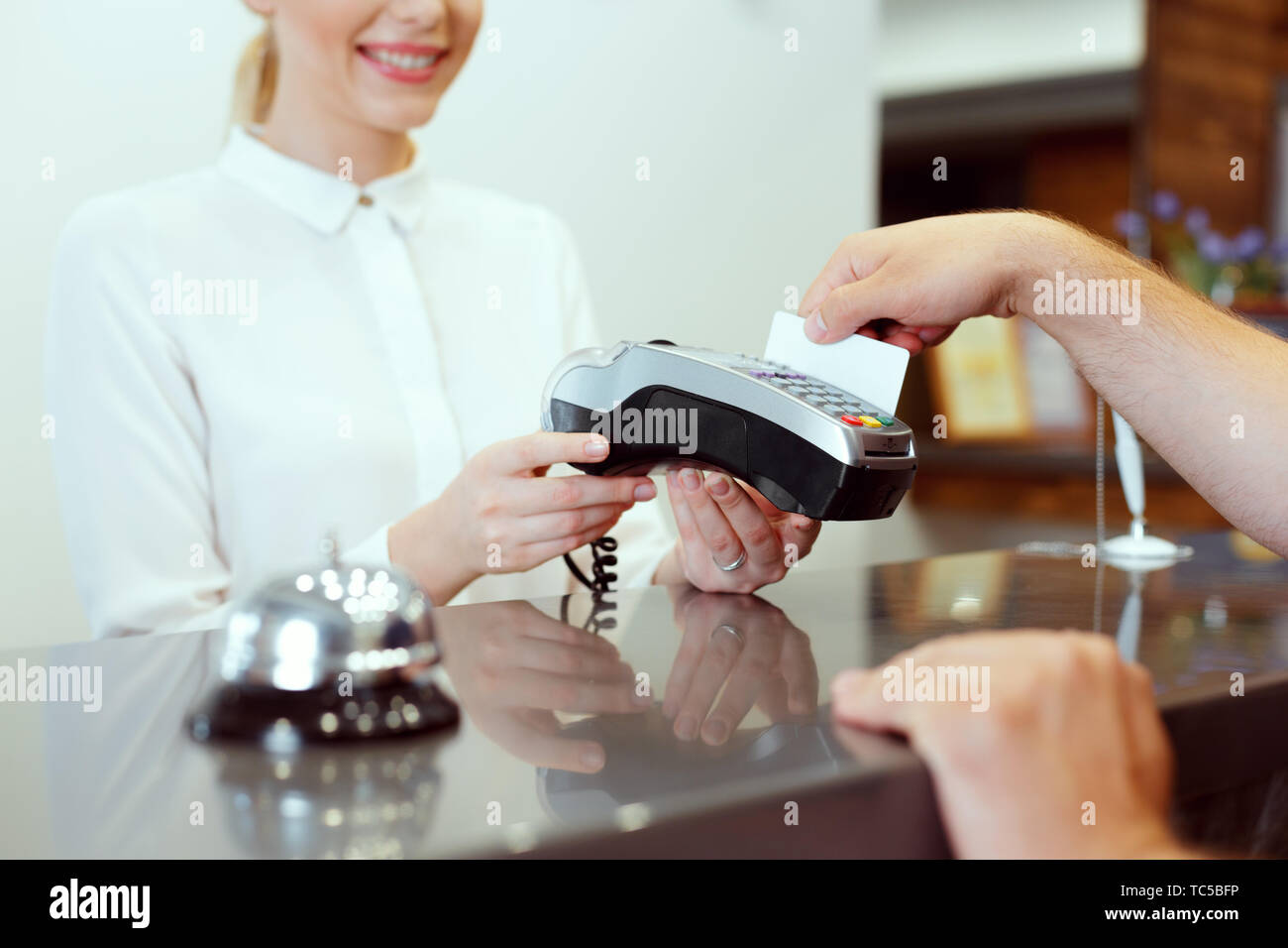 Guest at hotel reception paying with check during check-in Stock Photo ...