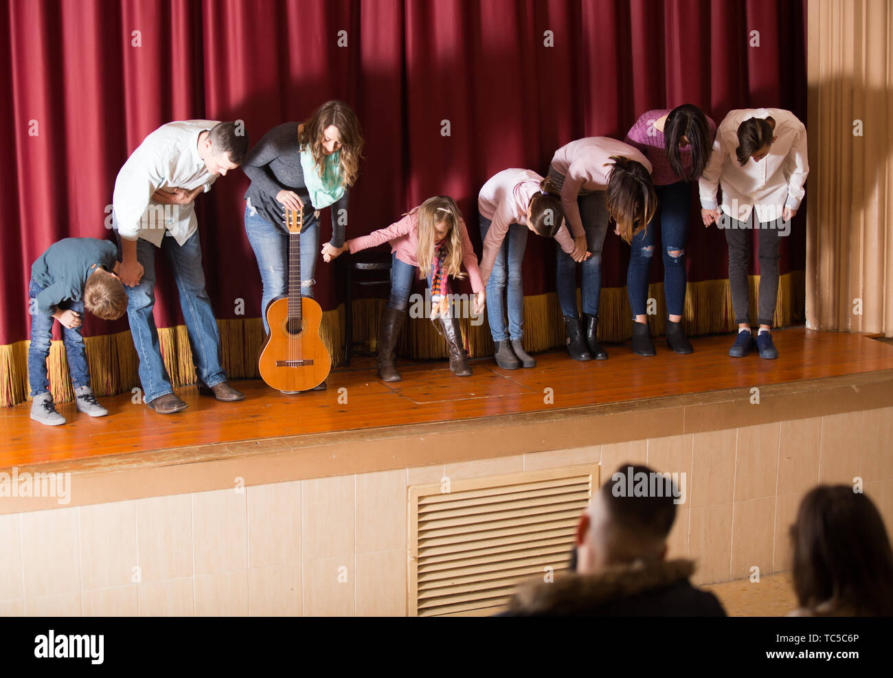 Performing people bowing to audience in concert hall Stock Photo - Alamy