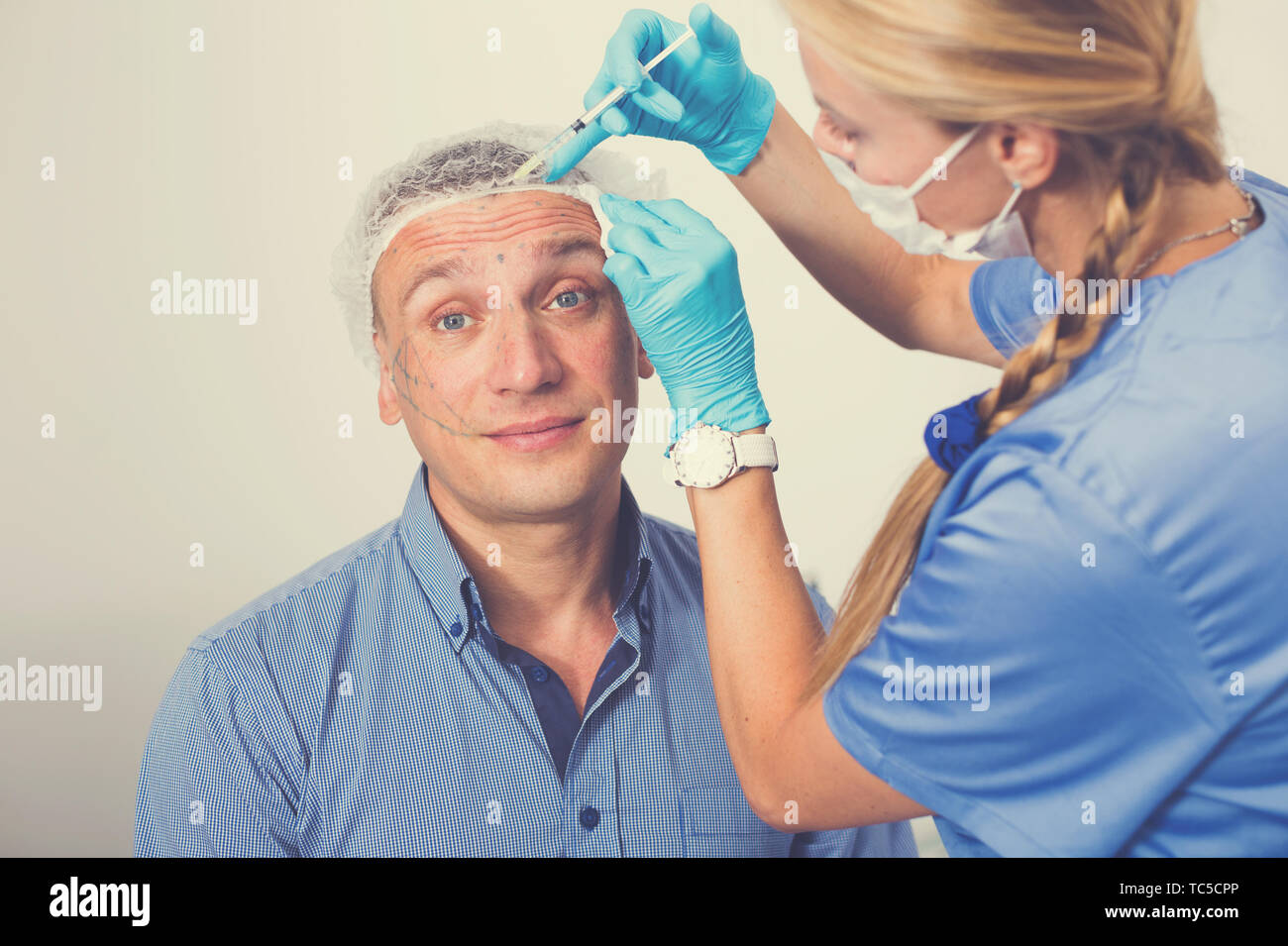 Female doctor is doing injection to patient in skin of face in estetic ...