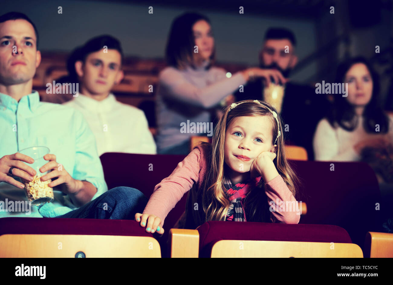 Little girl is bored watching movie in cinema house Stock Photo - Alamy