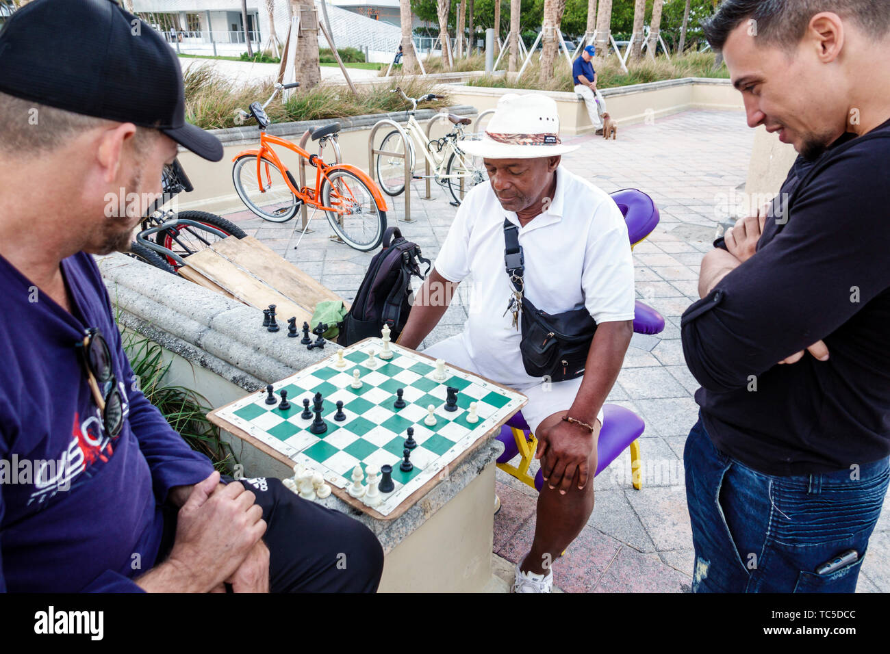 Hispanic black men playing watching chess game hi-res stock photography ...