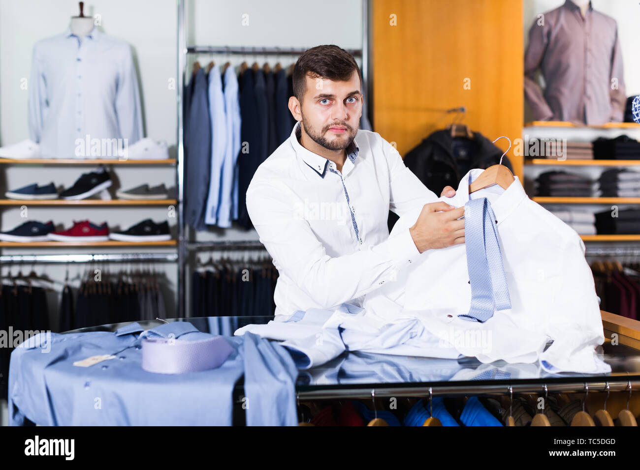 positive owner man offering shirt on sale in the mall Stock Photo - Alamy