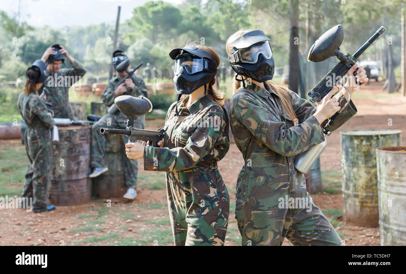 Portrait of female paintball players with marker guns ready for game ...