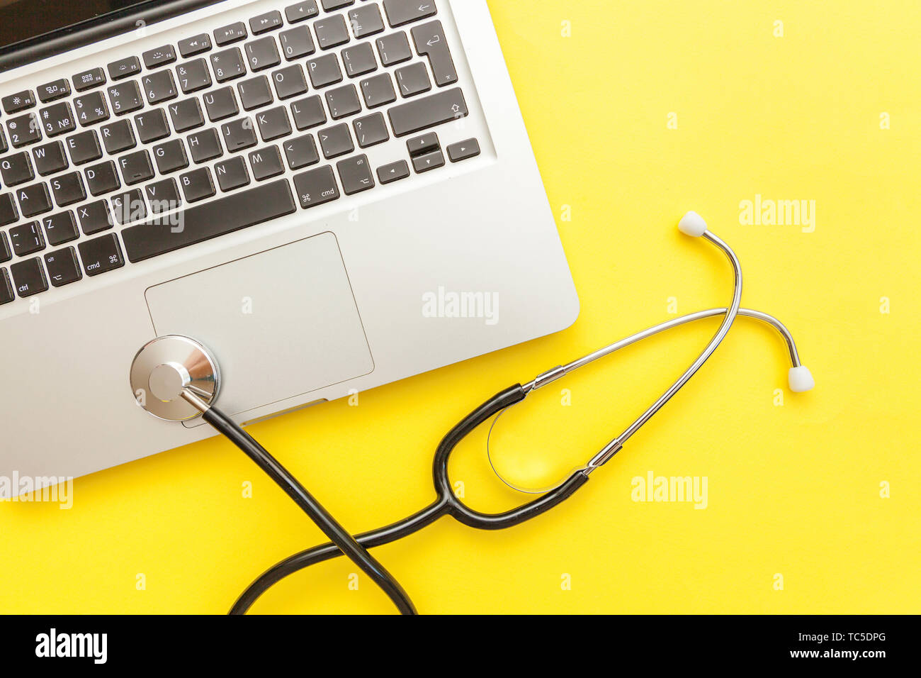 Stethoscope keyboard laptop computer isolated on yellow background ...