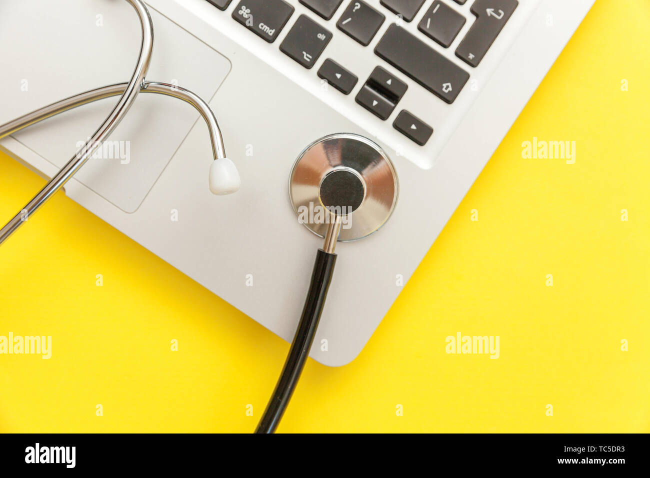 Stethoscope keyboard laptop computer isolated on yellow background ...