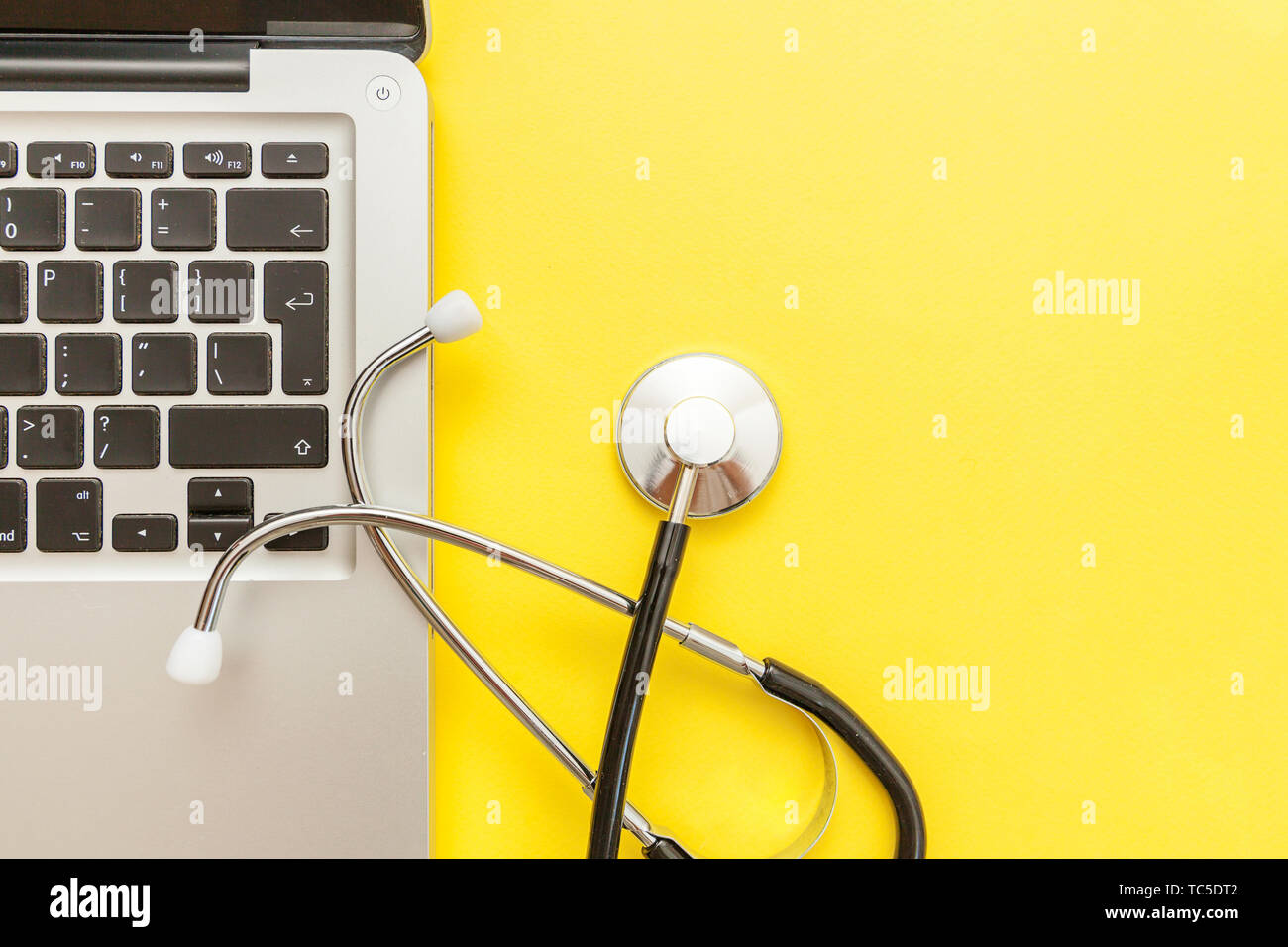 Stethoscope keyboard laptop computer isolated on yellow background ...