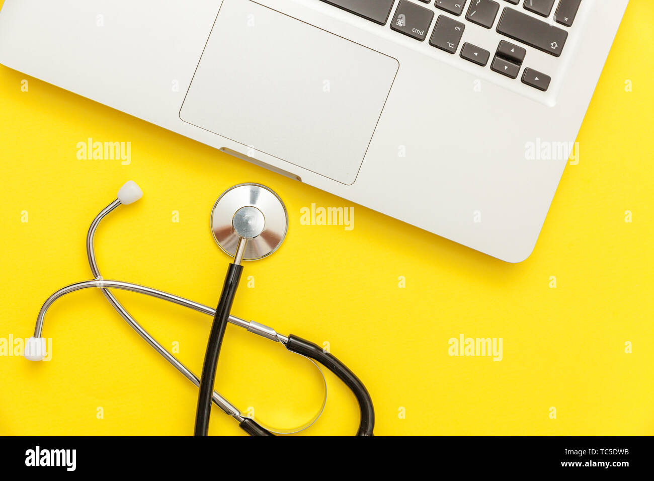 Stethoscope keyboard laptop computer isolated on yellow background ...
