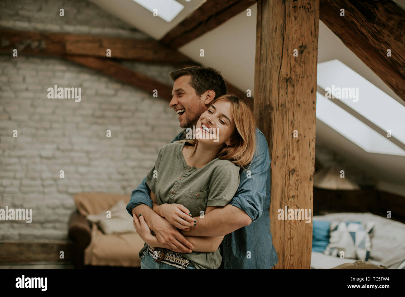 Young man and woman hugging standing at home interior and tender ...