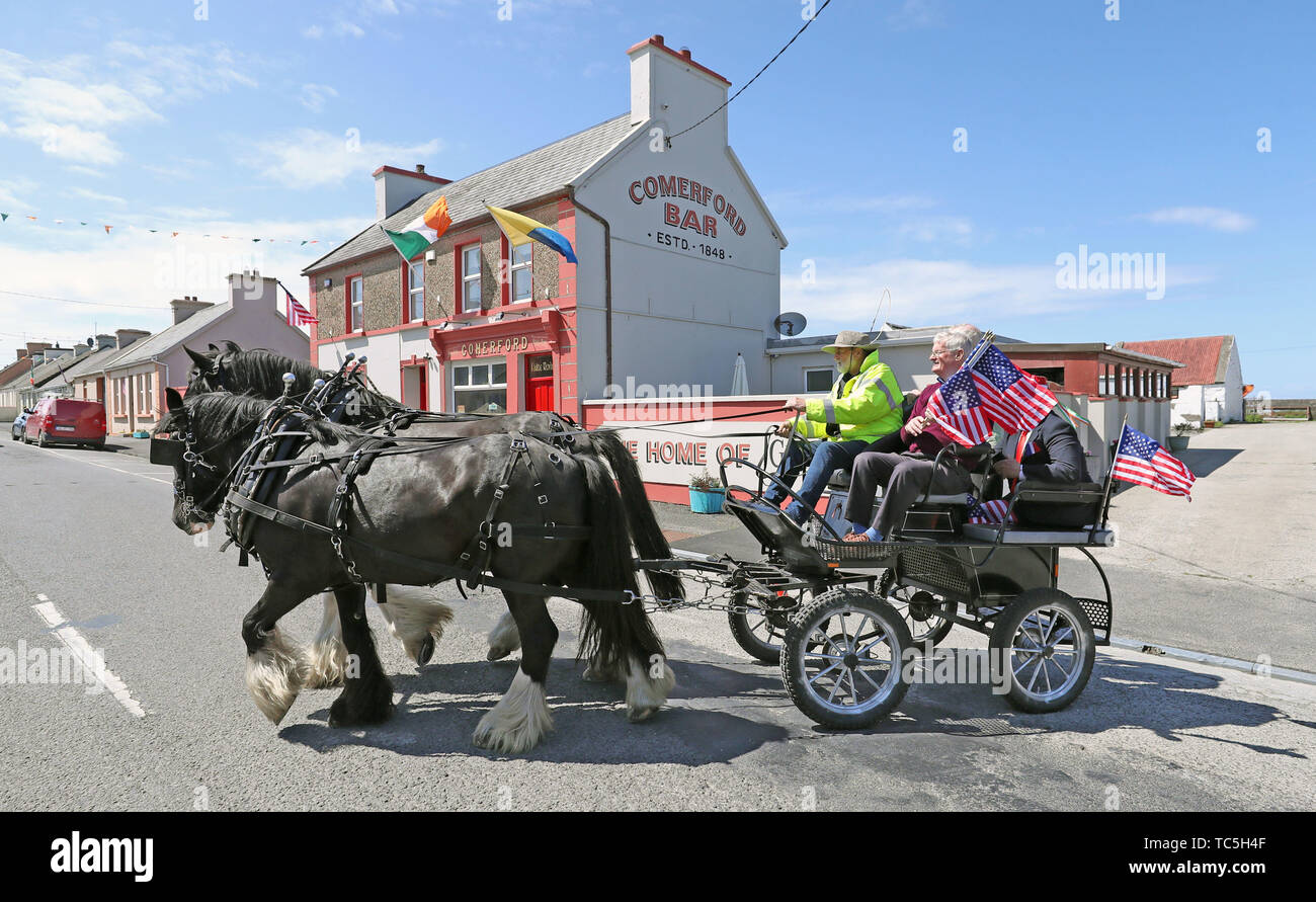 Locals wave flags as they tour around the village of Doonbeg in Co ...