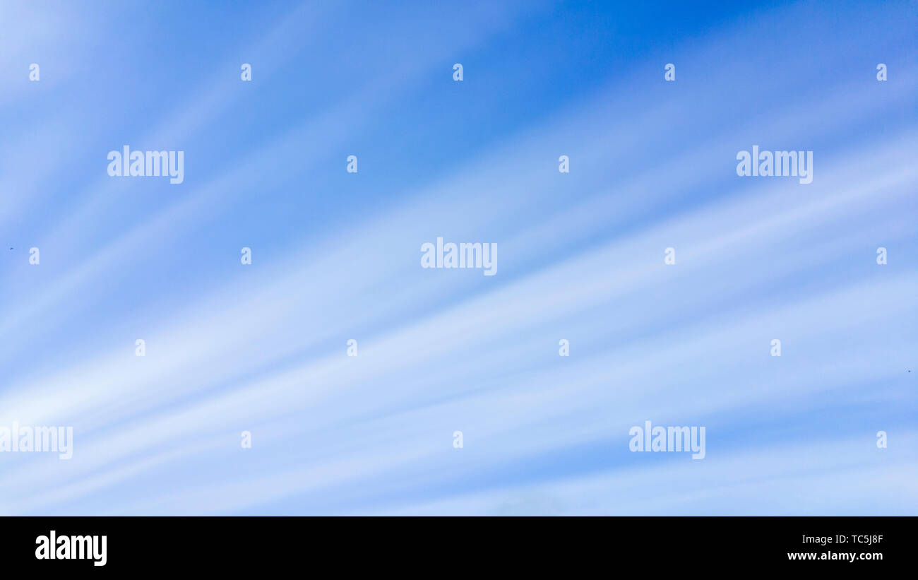Clouds formed as straight lines resembling sunbeams from an eclipse ...