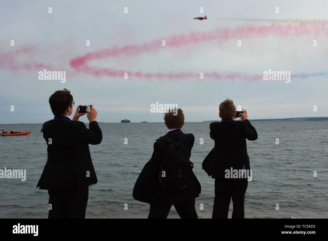 Local schoolchildren take pictures of the Red Arrow display over ...