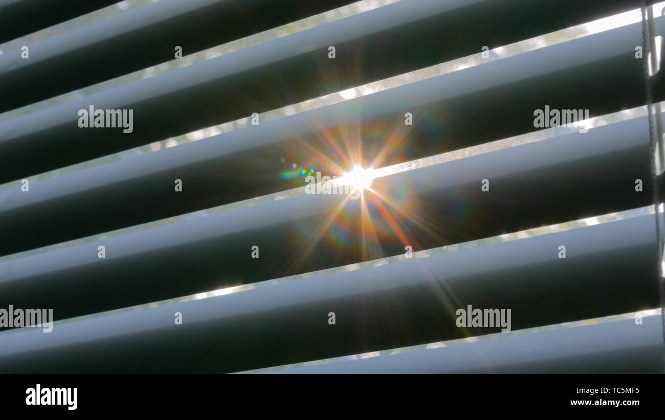 Sun lens flare through window louvers Stock Photo - Alamy