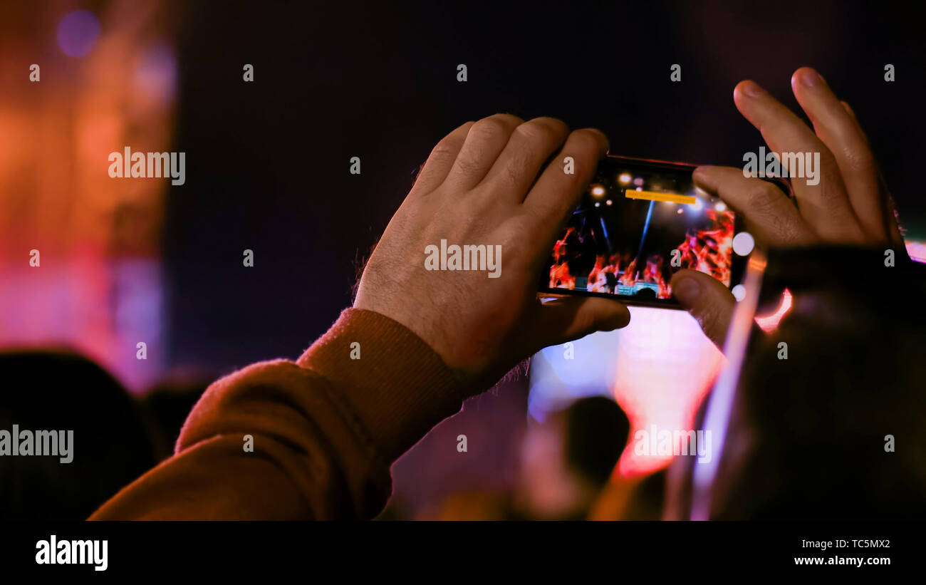Man hands silhouette recording video of live music concert with ...