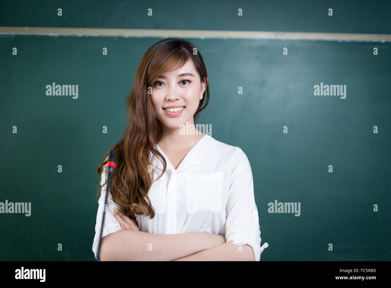 Asian beautiful woman speaking in front of blackboard with micro Stock ...