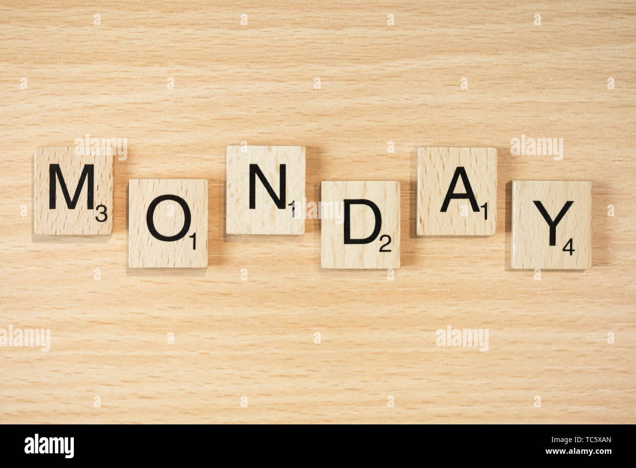 The word Monday, spelt out using wooden tiles on a wood effect ...