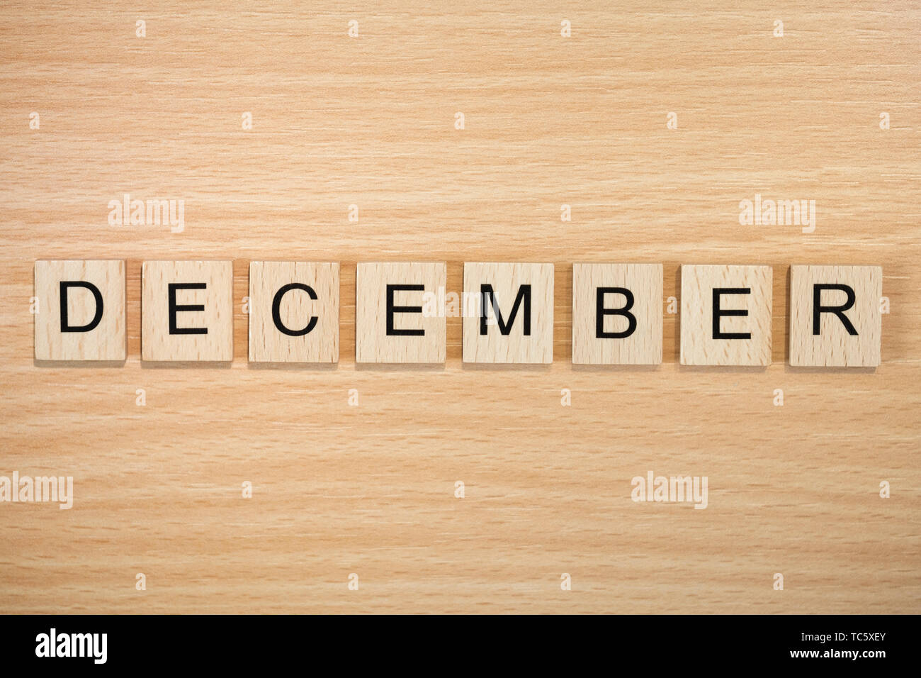The word December, spelt out using wooden tiles on a wood effect ...