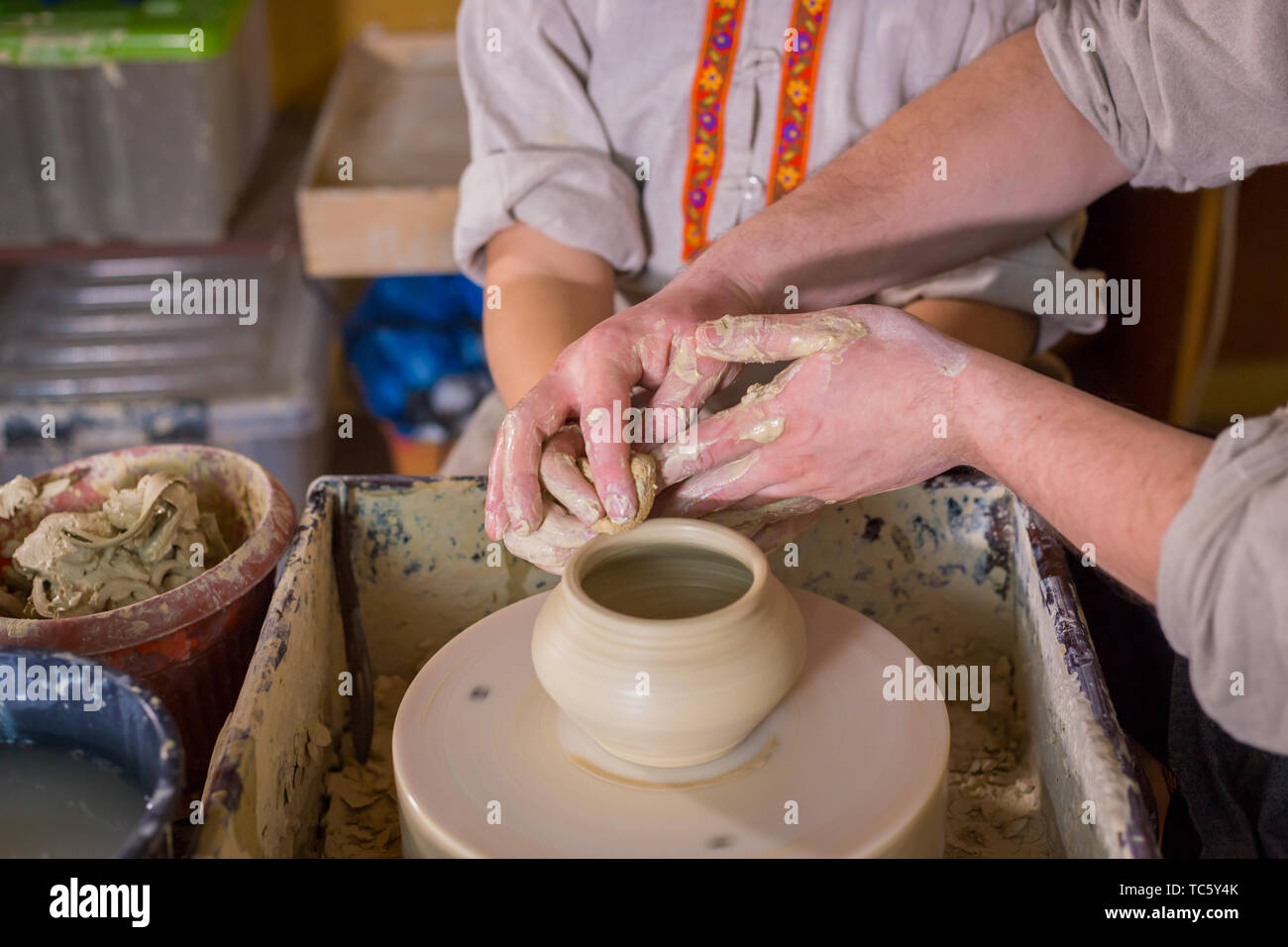 Potter showing how to work with ceramic in pottery studio Stock Photo ...