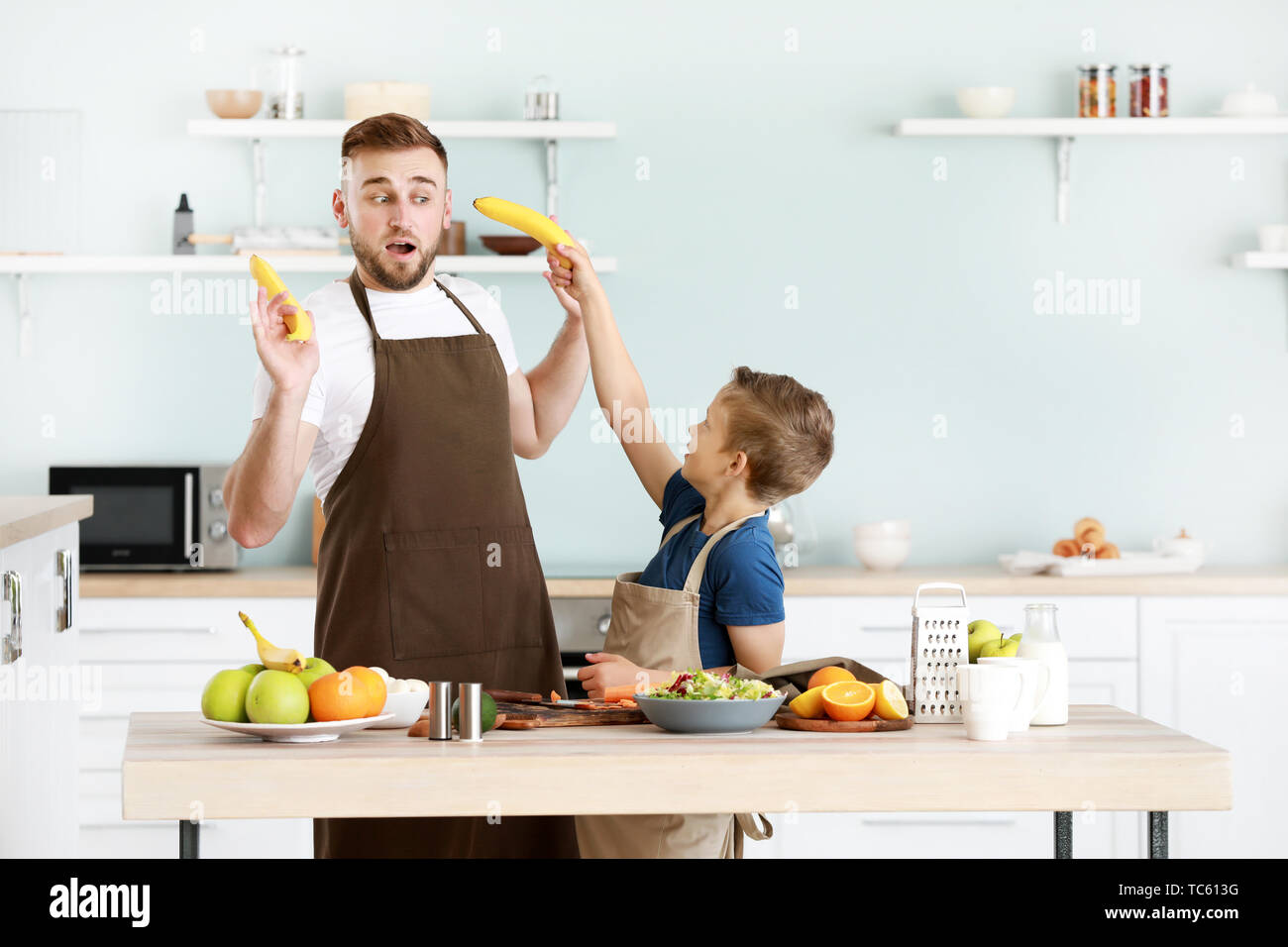 Portrait of father and son having fun while cooking in kitchen Stock ...