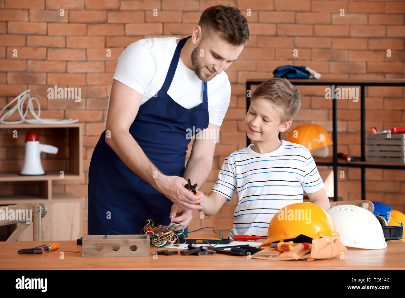Father teaching his little son to handle with tools at home Stock Photo ...