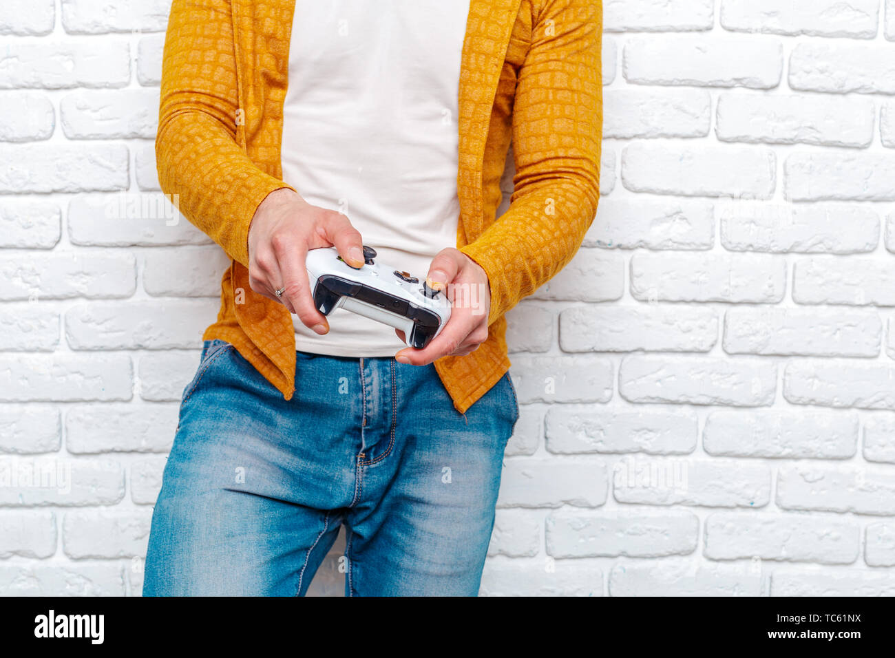 A young man holding game controller playing video games Stock Photo - Alamy
