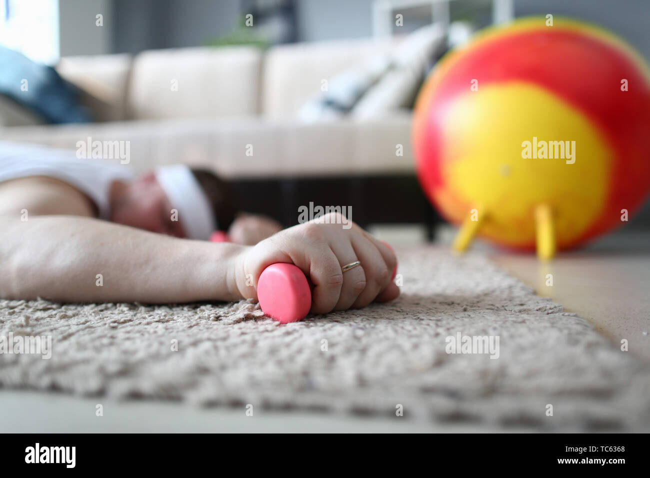 Tired Man Lying on Floor with Dumbbell in Hand Stock Photo - Alamy