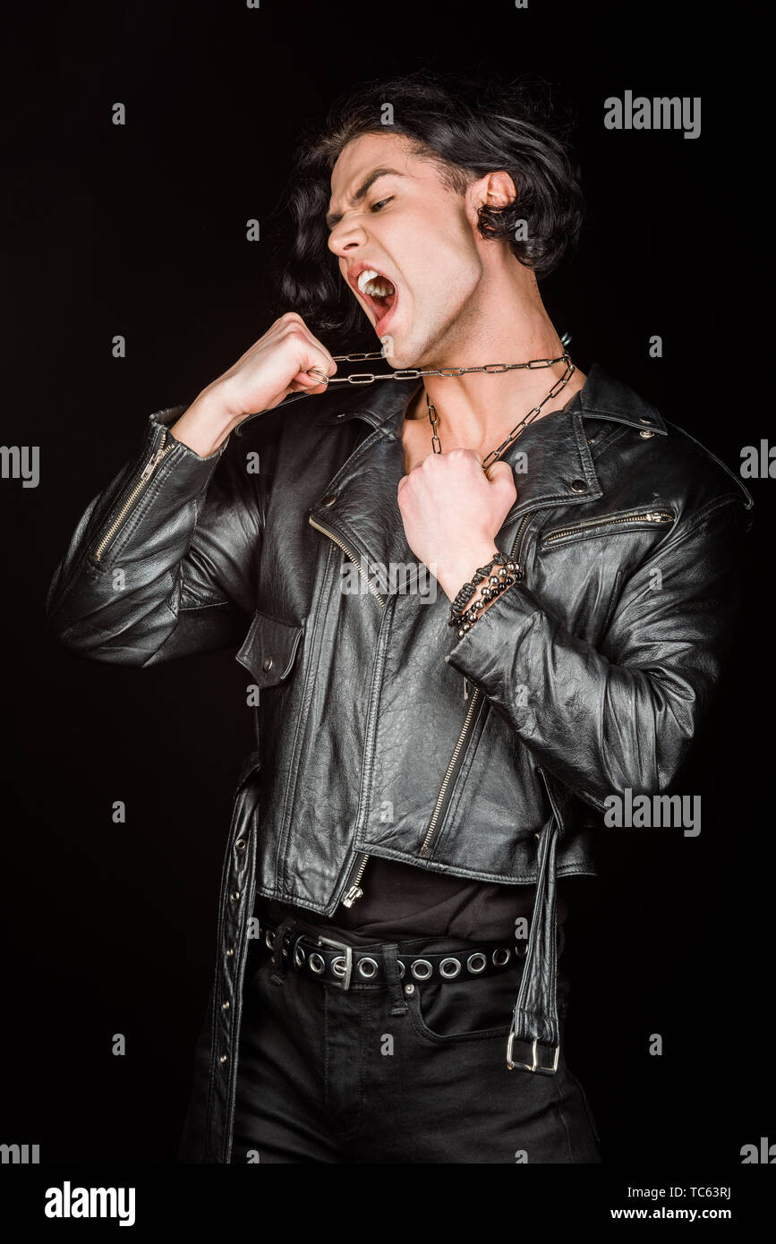 emotional man touching chains on neck while screaming isolated on black ...