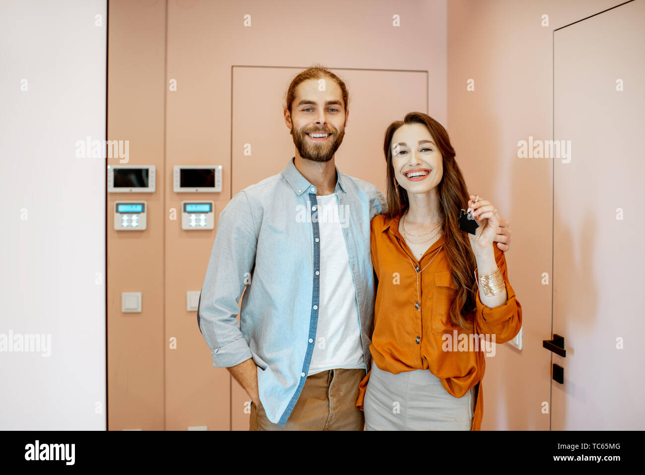 Portrait of a young happy couple standing together with keys at the ...