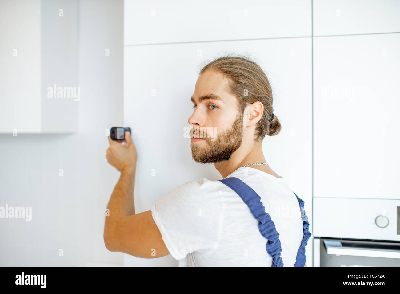 Handyman measuring distances with electronic measurement tool in the ...