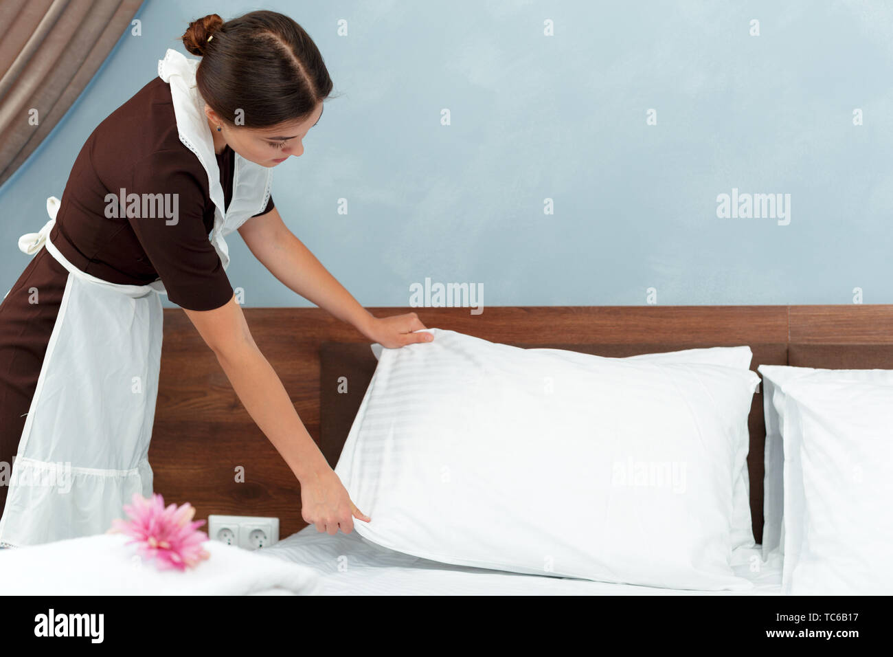 Young maid making bed in hotel room Stock Photo - Alamy