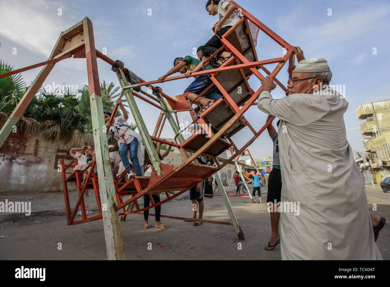 Baghdad, Iraq. 05th June, 2019. Iraqi children sit on a swing during ...