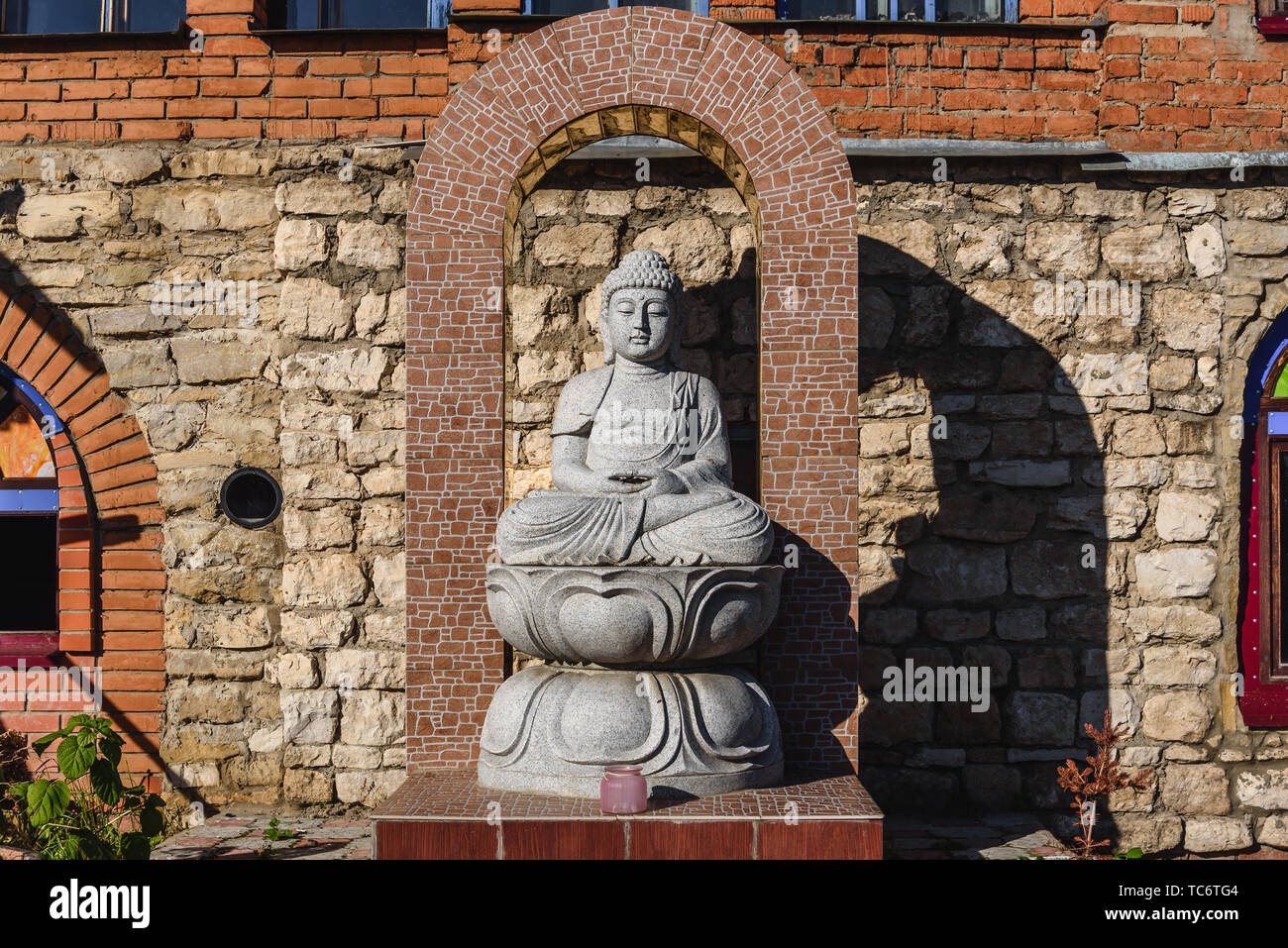 White stone statue of a Buddha on masonry background Stock Photo - Alamy