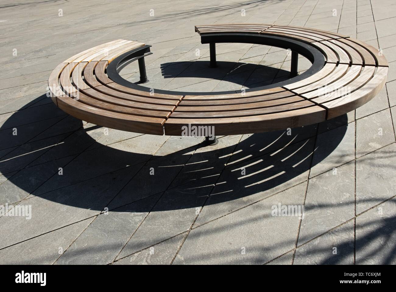 Wooden modern trendy design round circular park bench Stock Photo - Alamy