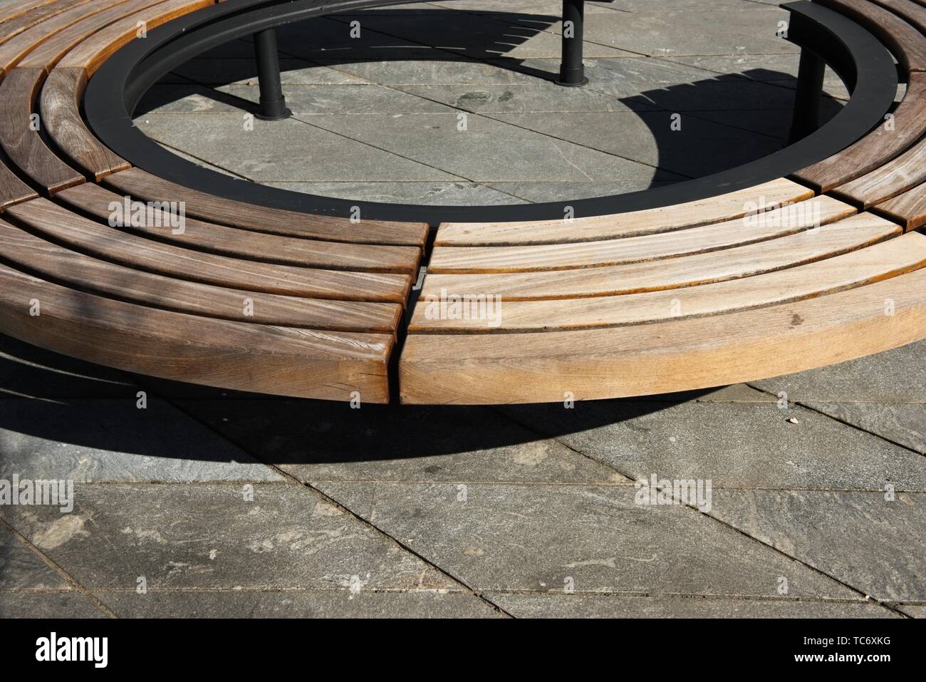 Wooden modern trendy design round circular park bench Stock Photo - Alamy