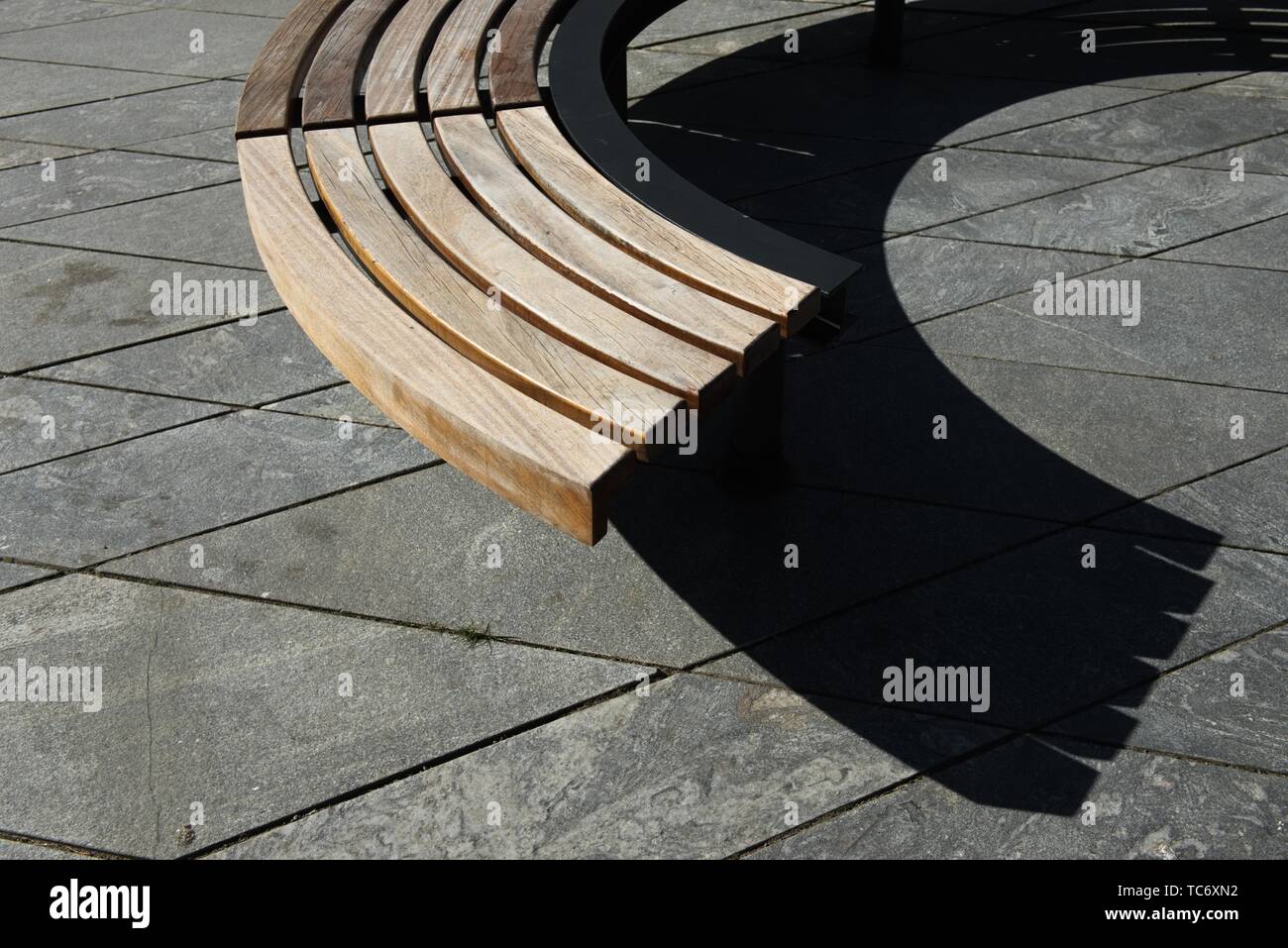 Wooden modern trendy design round circular park bench Stock Photo - Alamy