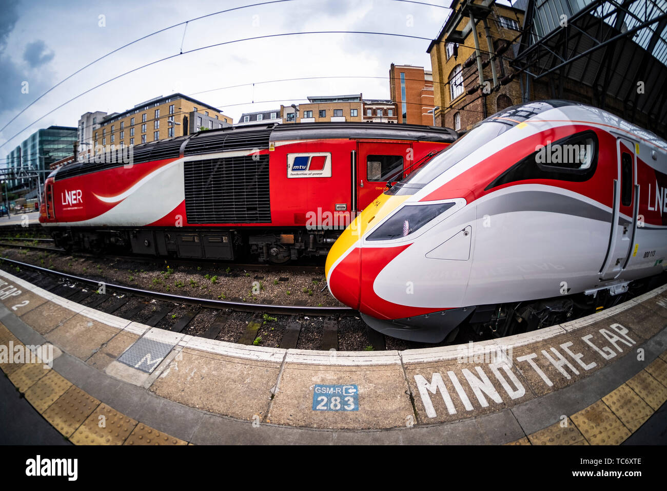 A New LNER Azuma train sits alongside an old diesel HST train at London Kings Cross Station, UK ...