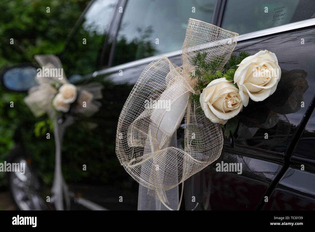 Wedding black car decorated with white roses Stock Photo - Alamy