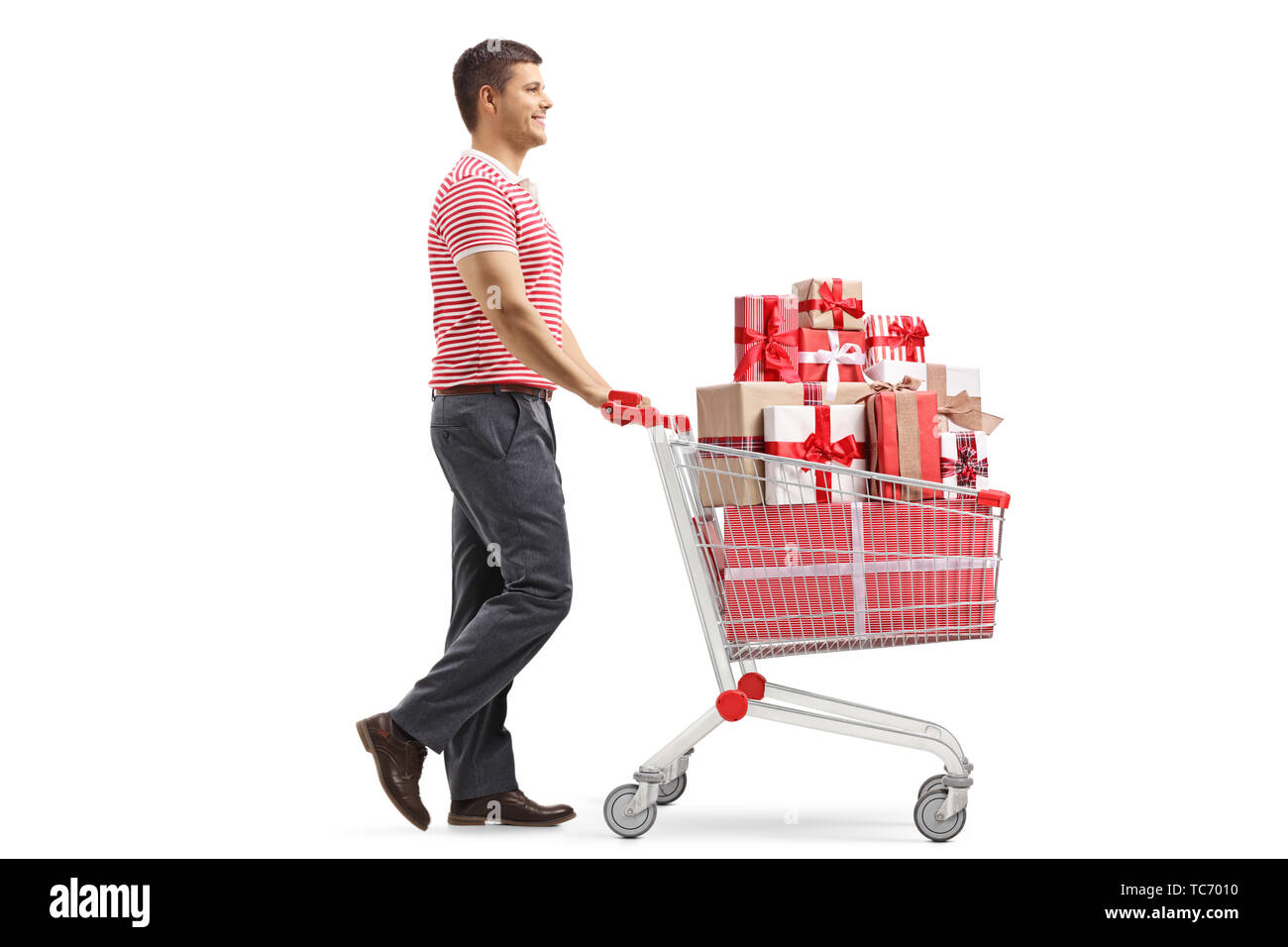Full length profile shot of a cheerful young man with a shopping cart ...