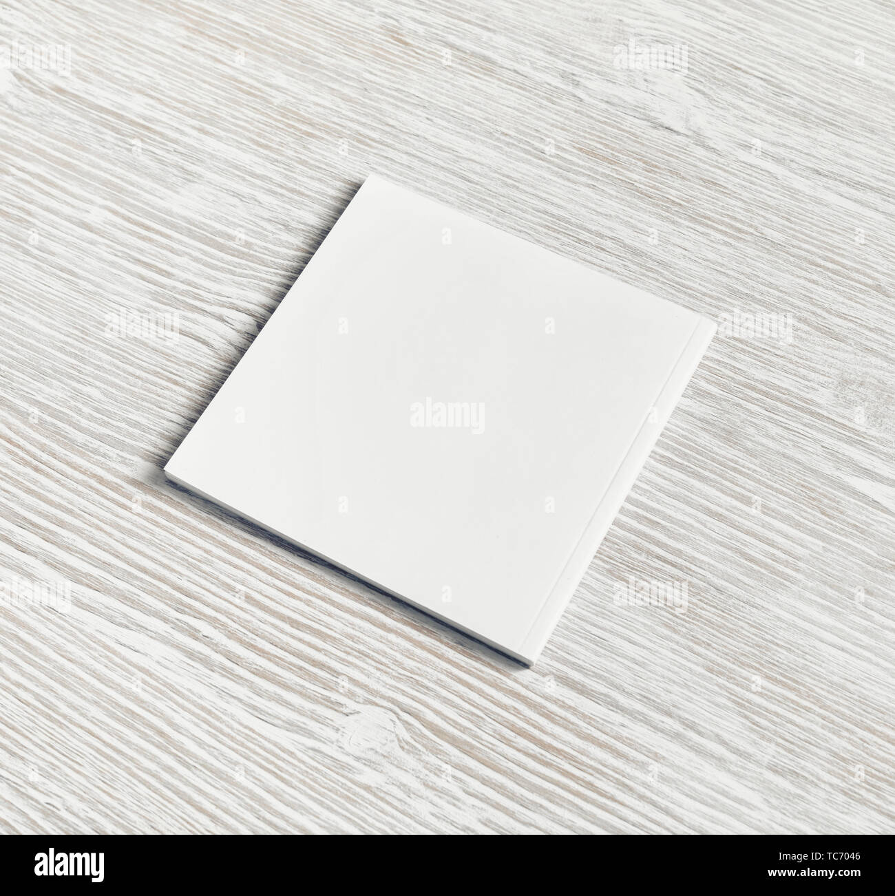 Blank square notebook on light wood table background. White paper ...