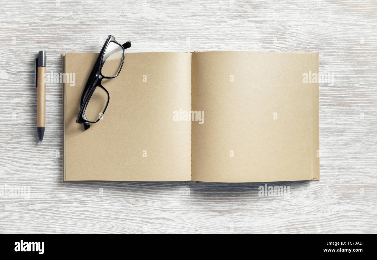 Photo of blank notepad with blank kraft paper pages, pen and glasses on ...