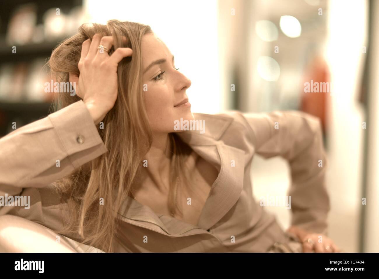 side view of fashionable woman with rumpled hair, in Munich, Germany ...