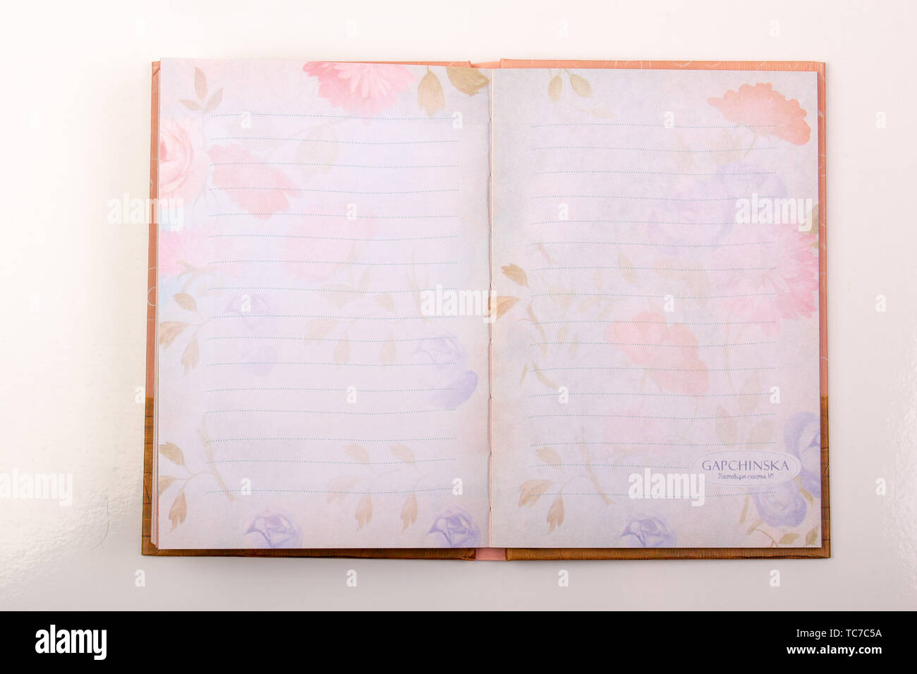 An open notebook on the table on a white background. Diary with pink ...