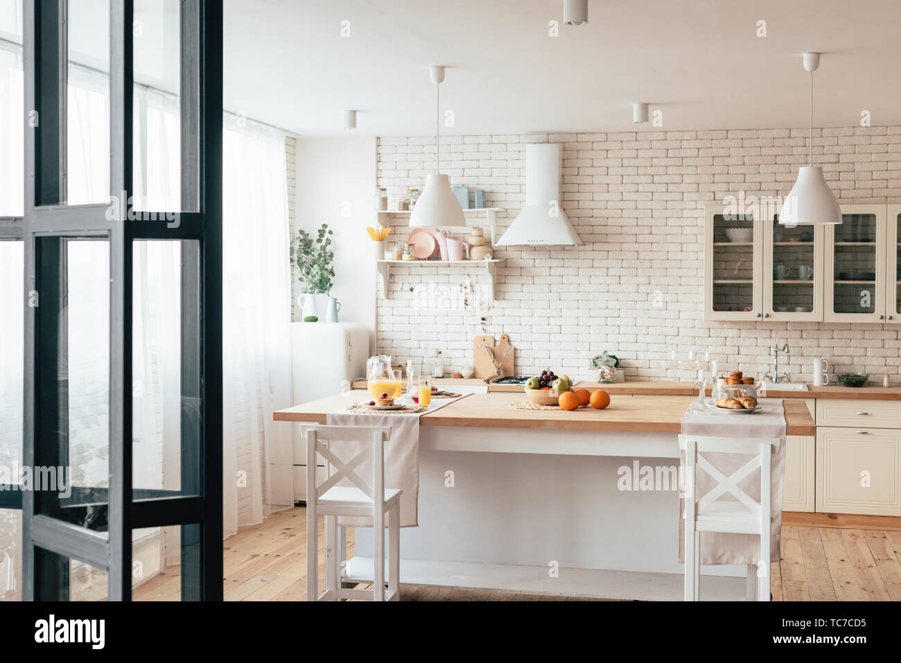 cozy modern kitchen with served table and chairs Stock Photo - Alamy