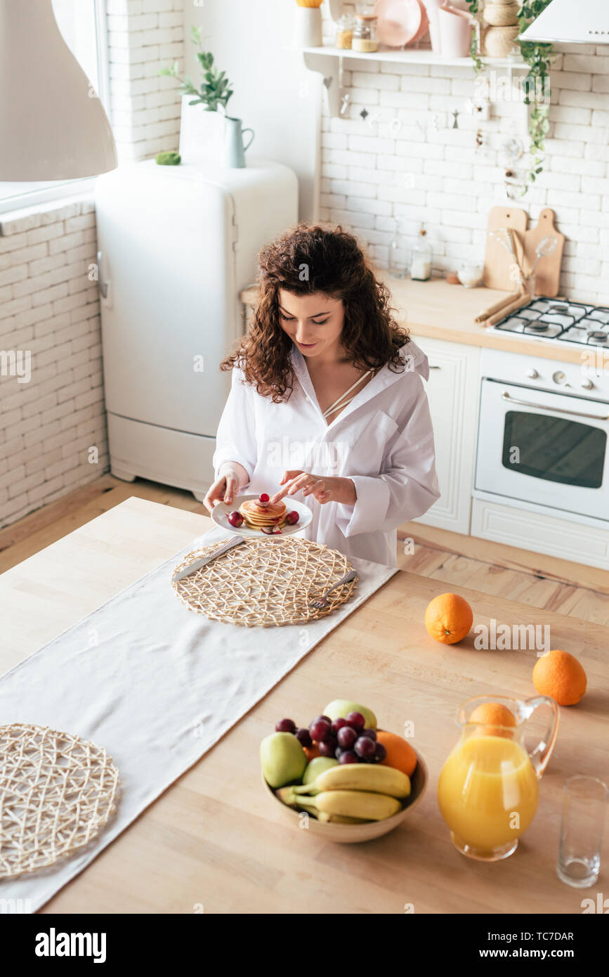 overhead view of pretty woman eating pancakes in kitchen Stock Photo ...