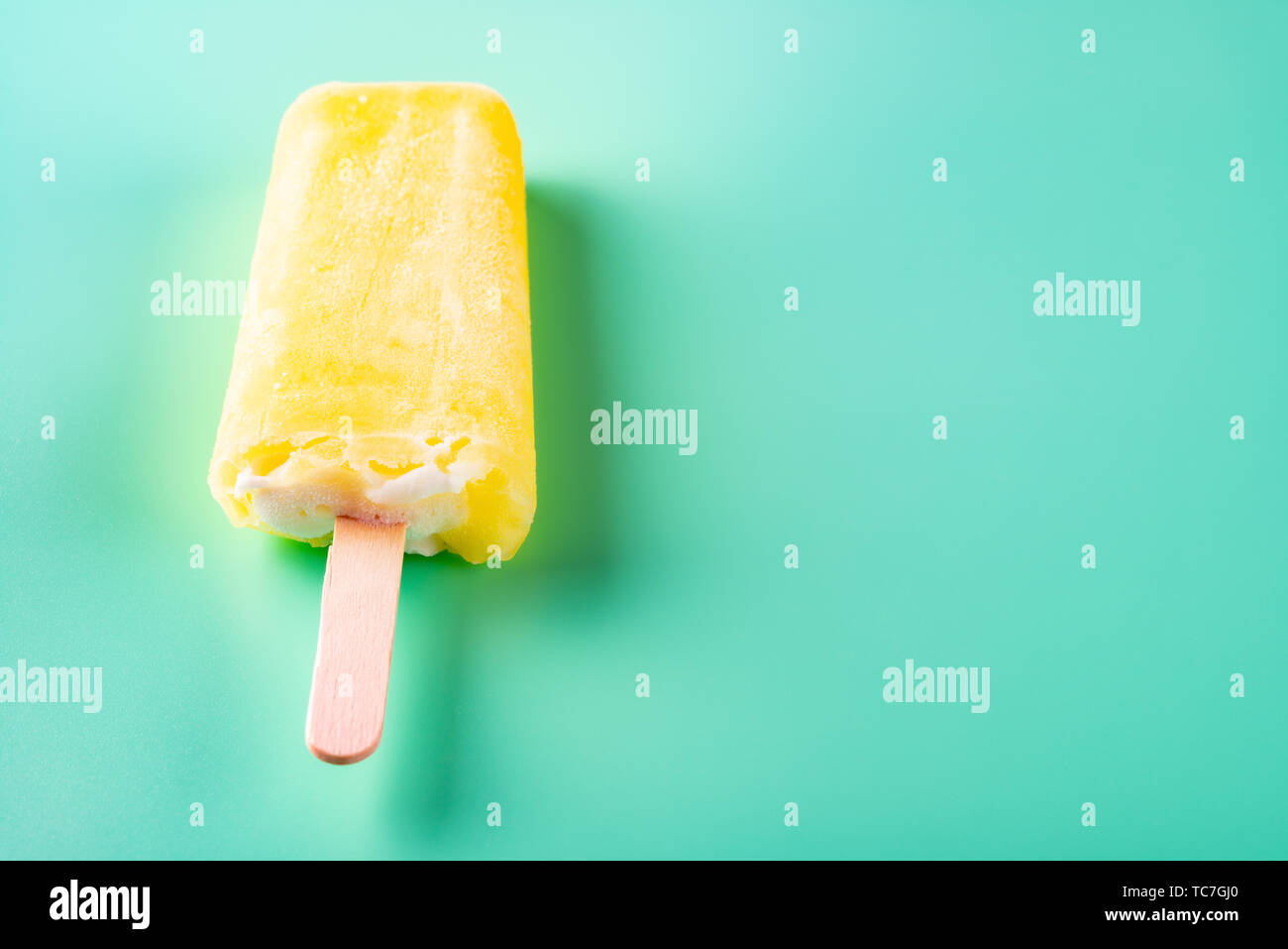 side view yellow popsicle on a light green background Stock Photo - Alamy