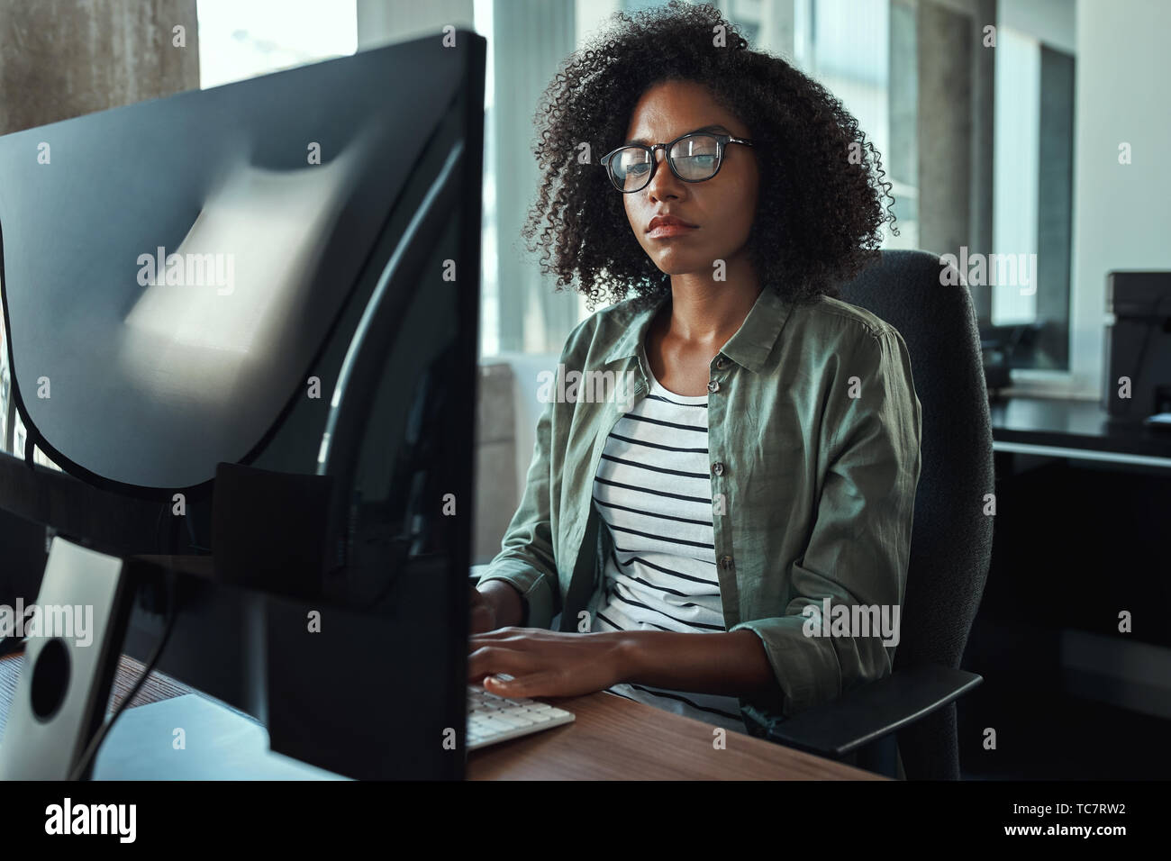 Young african businesswoman typing on desktop keyboard Stock Photo - Alamy