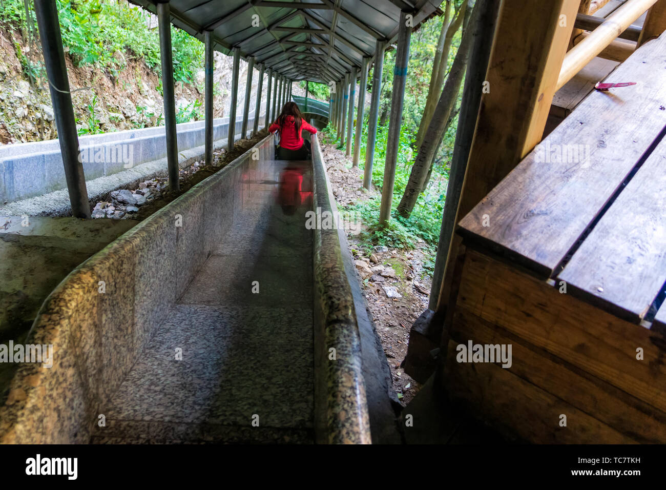Young woman sliding down on The Marble Slide of Zhangjiajie in Grand ...