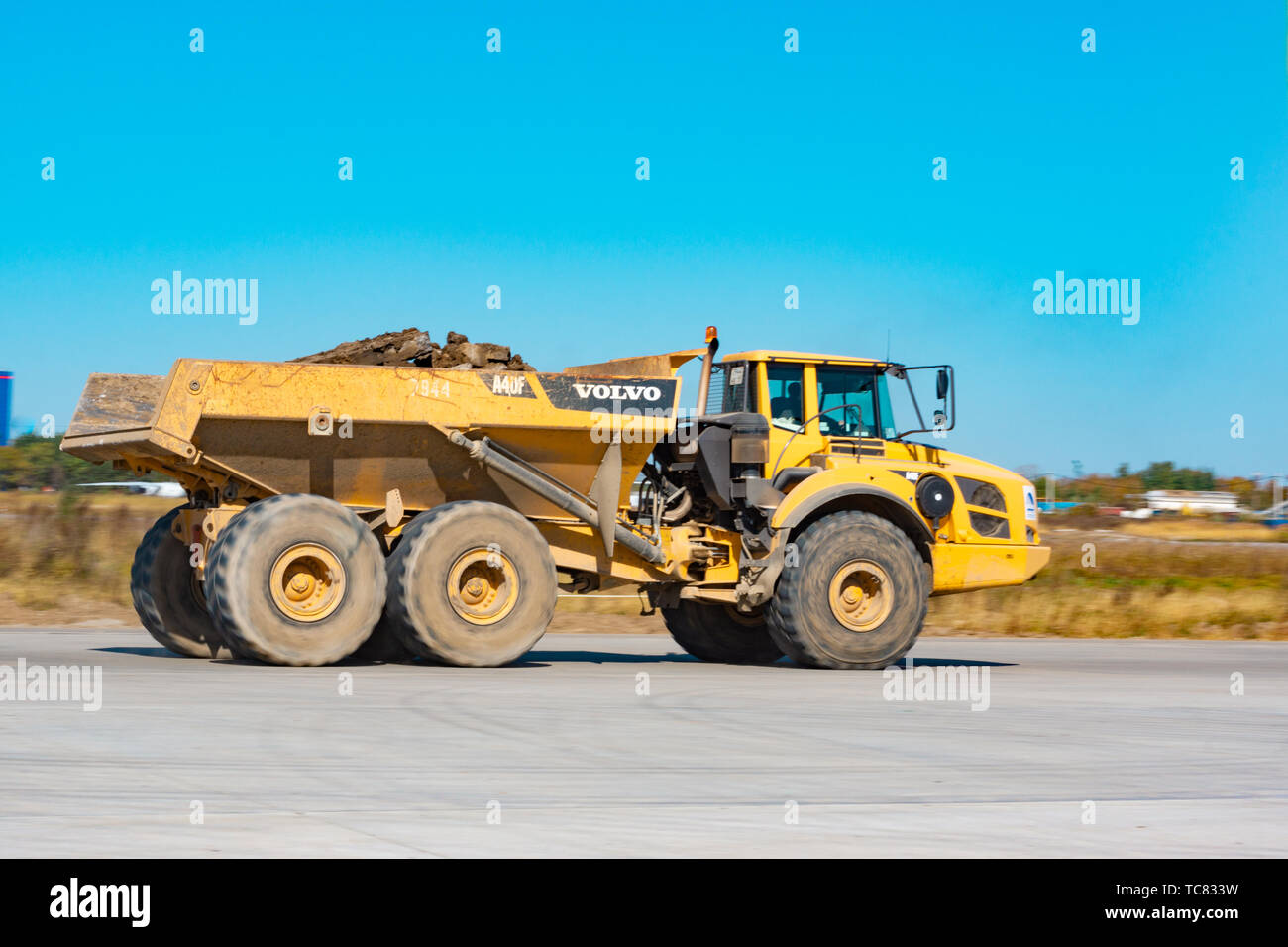 The yellow articulated truck Volvo A40F is working at the airport in ...