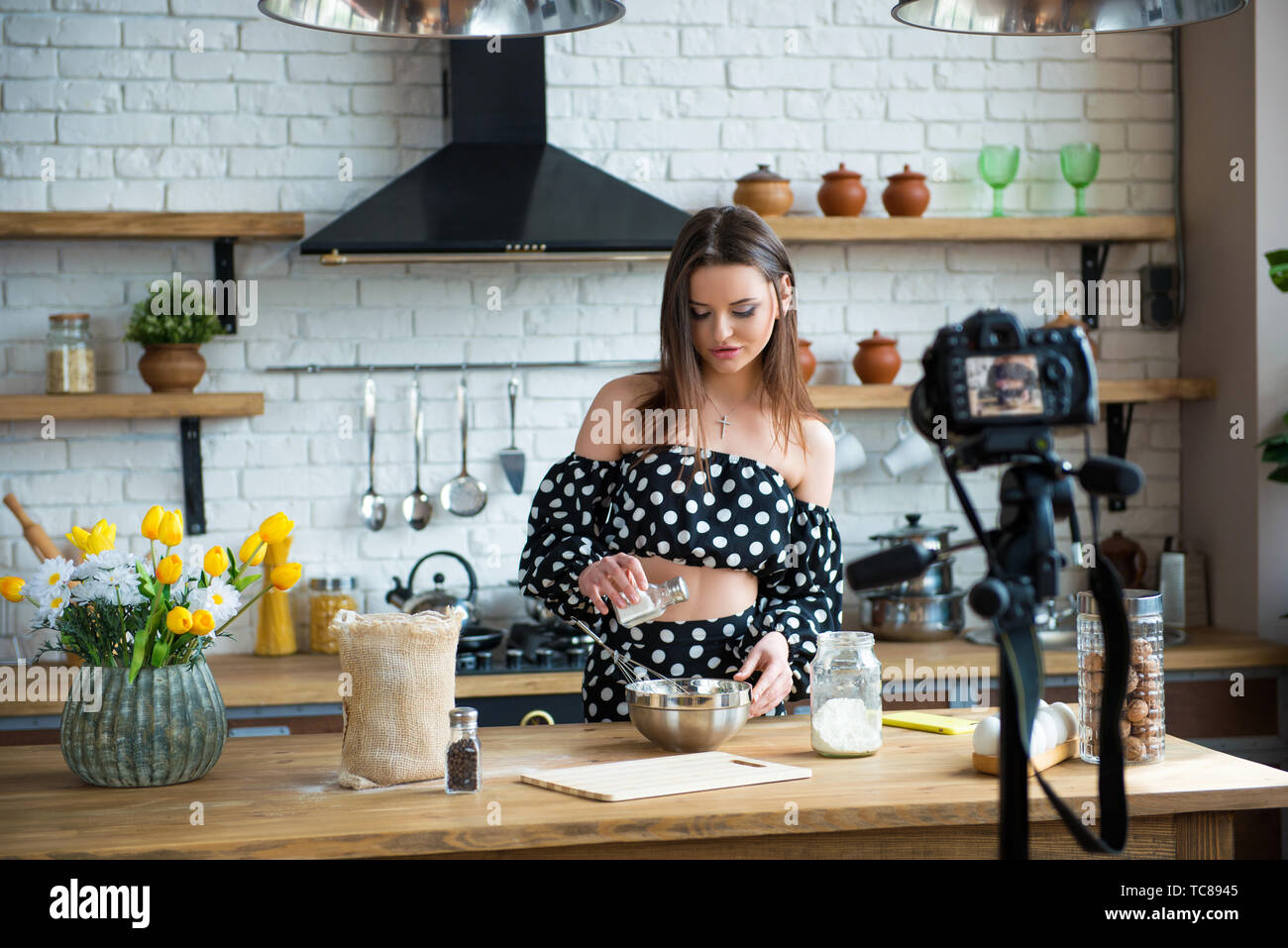 Pretty young woman girl food blogger in polka dot dress working on a ...