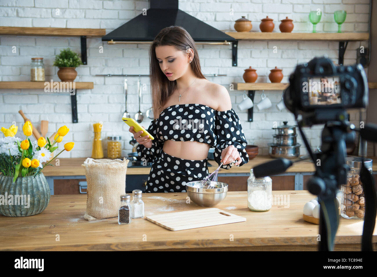 Pretty young woman girl food blogger in polka dot dress working on a ...